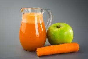 Receta para el jugo de la zanahoria de Apple para el invierno en casa a través del exprimidor.