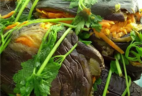 Terong Sauer dengan tanaman hijau wortel dan bawang putih di atas meja