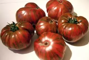 Beschreiwung an Charakteristike vun Tomaten Tomaten Varietéiten gestreift Schockela, hire Rendement