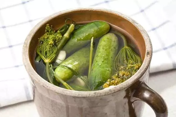 Acute low-headed cucumbers in a saucepan of hot brine