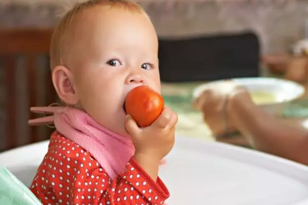 Kind eet tomaat